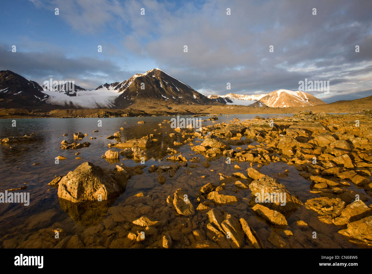 Norway, Svalbard, Spitsbergen, Rising midnight sun lights glacier ...
