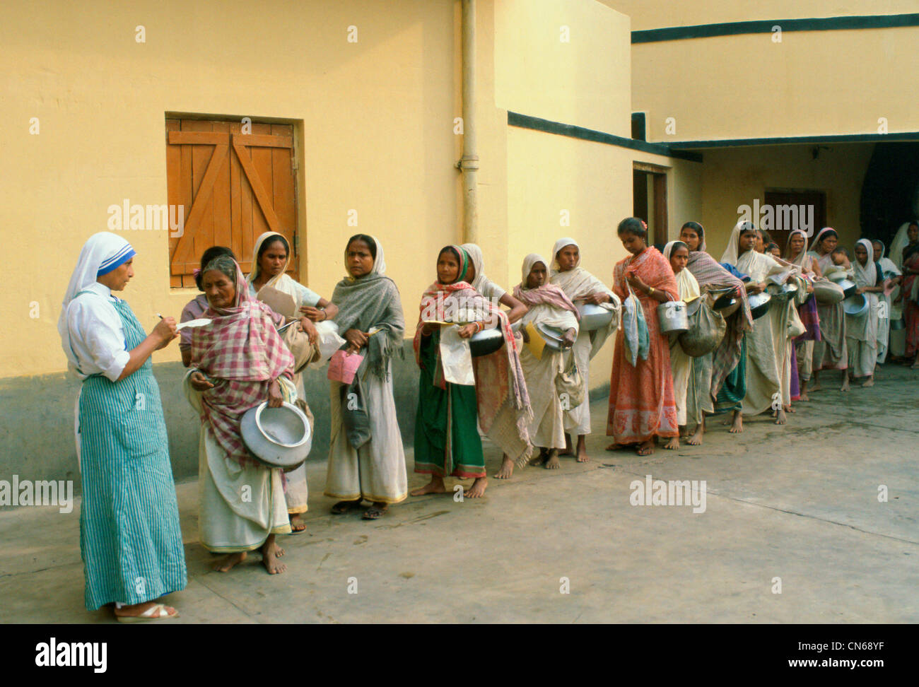 Women carrying pots in early morning food queue at Mother Teresa's ...