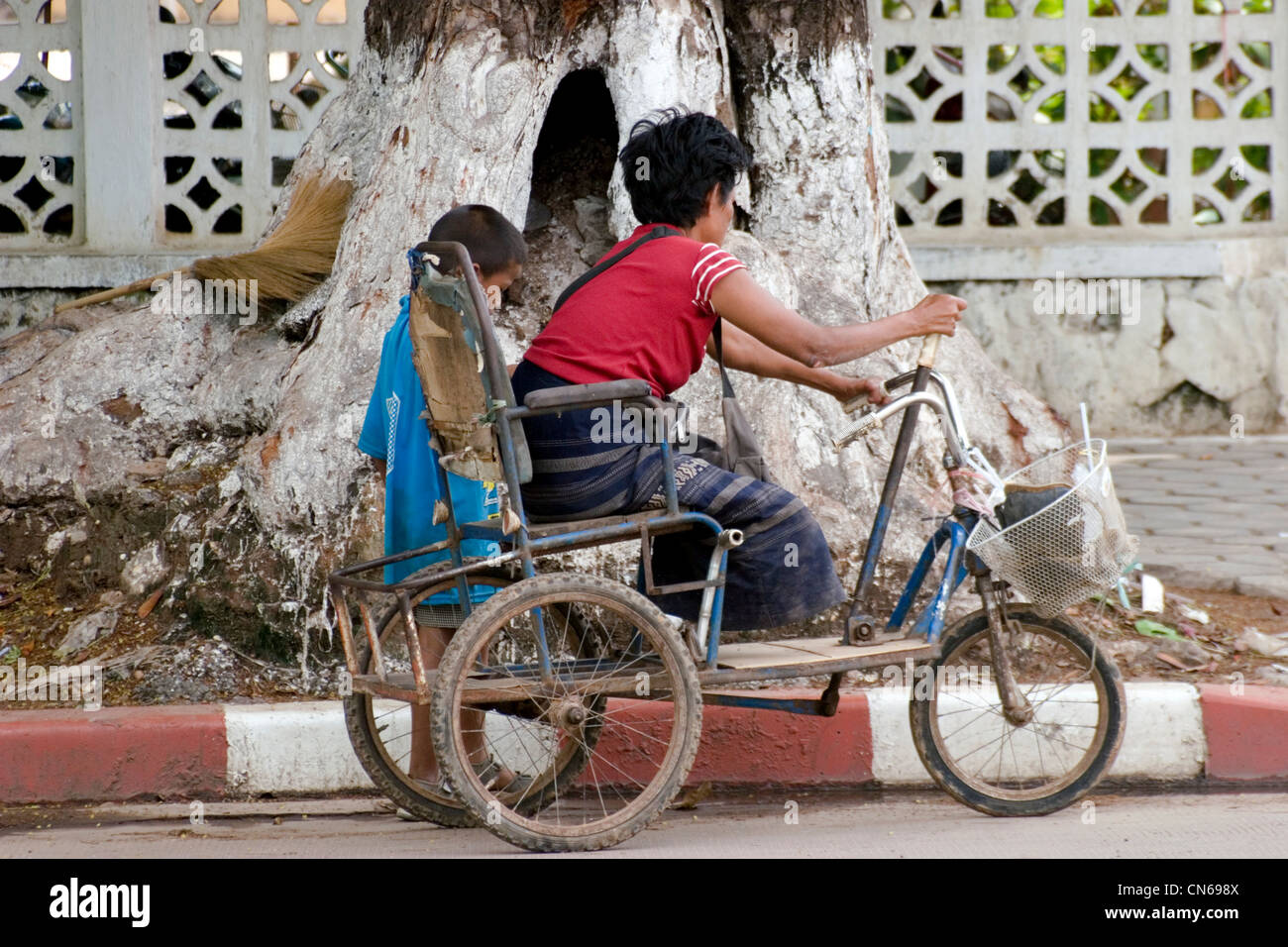 A handicapped woman without feet is peddling a wheelchair with her ...