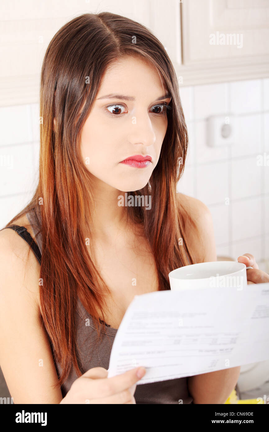 Stressed young caucasian woman in the kitchen drinking something hot ...