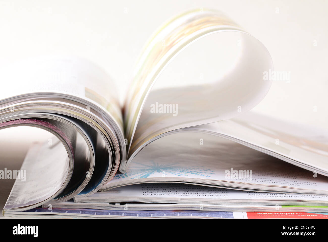 pile open magazines on a white background Stock Photo - Alamy