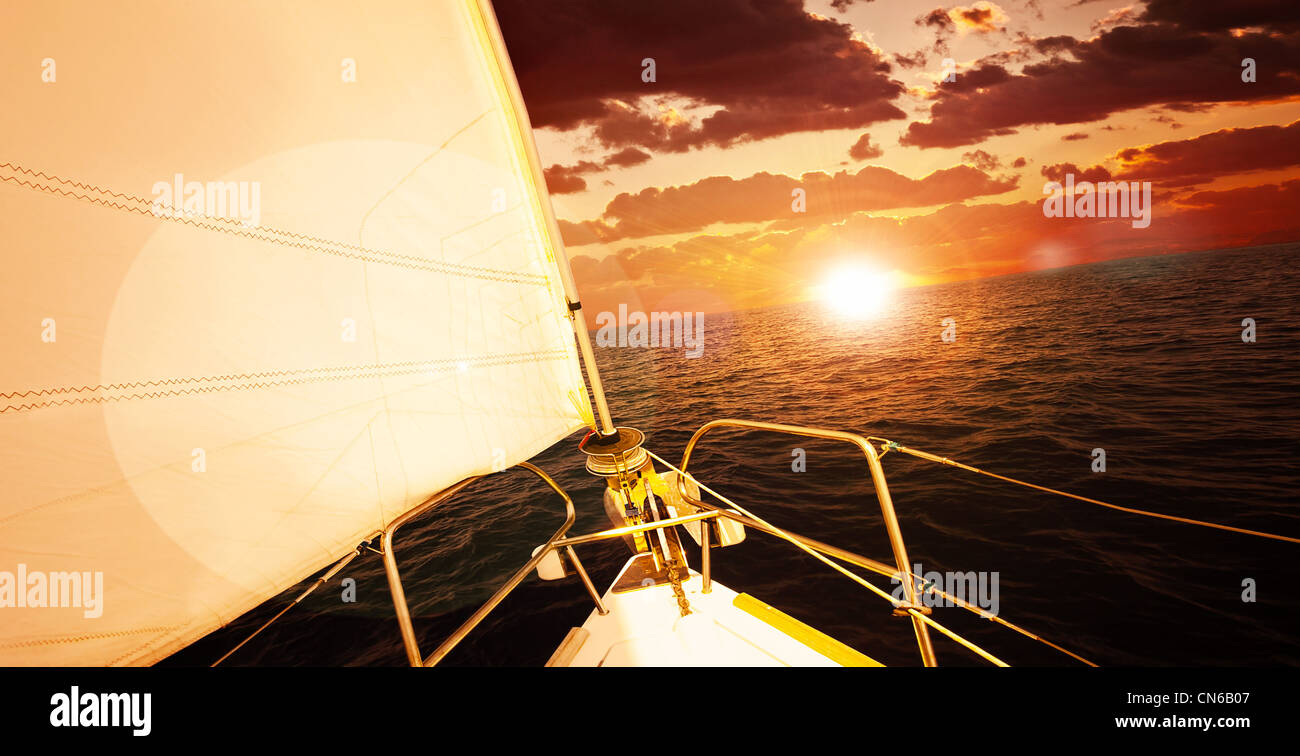 Romantic sunset and sail boat, dramatic sky with red clouds and sun ...