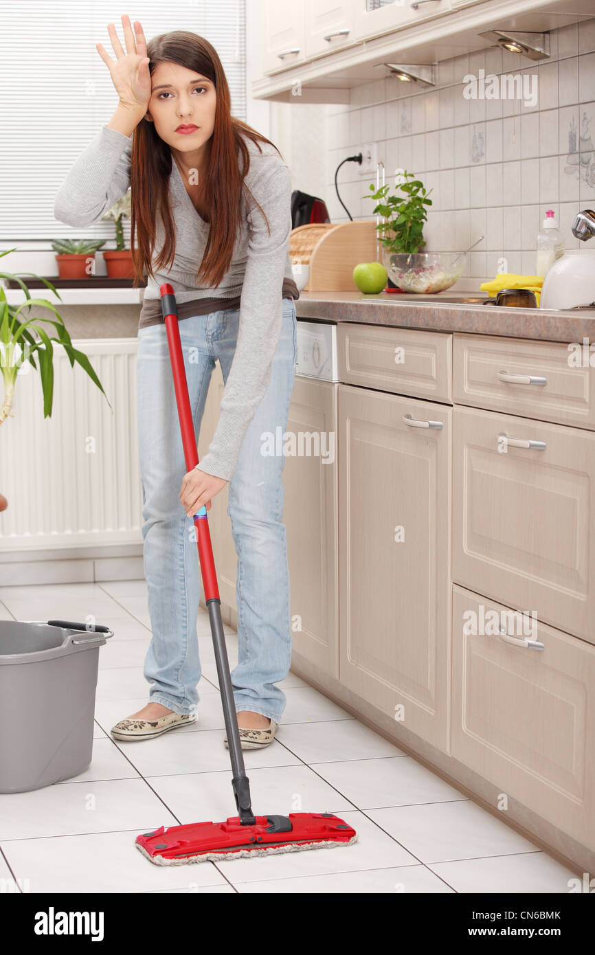 Woman holding a mop and cleaning kitchen floor Stock Photo - Alamy