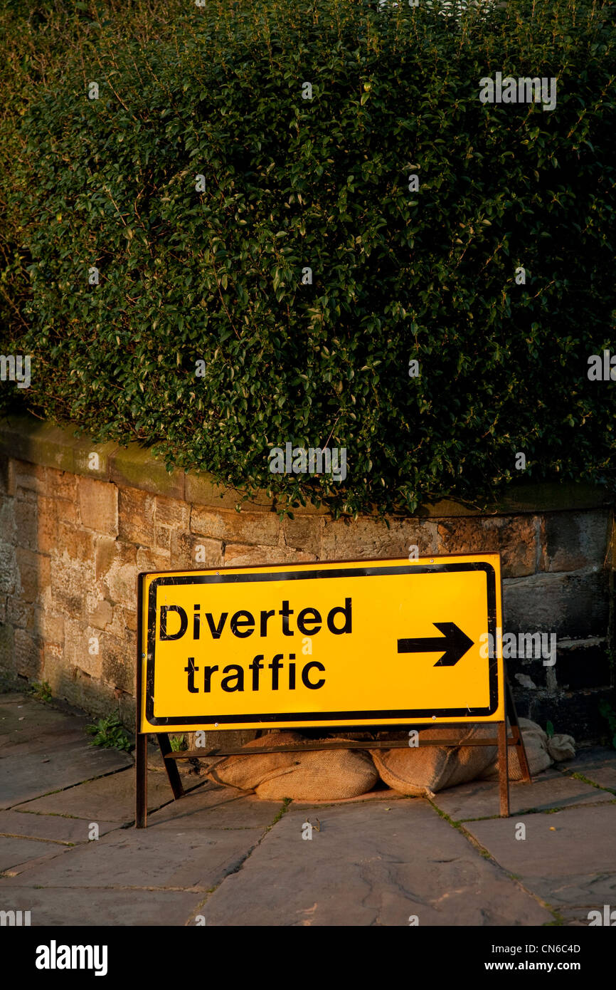 diverted traffic highways sign on a street corner by a garden wall and ...