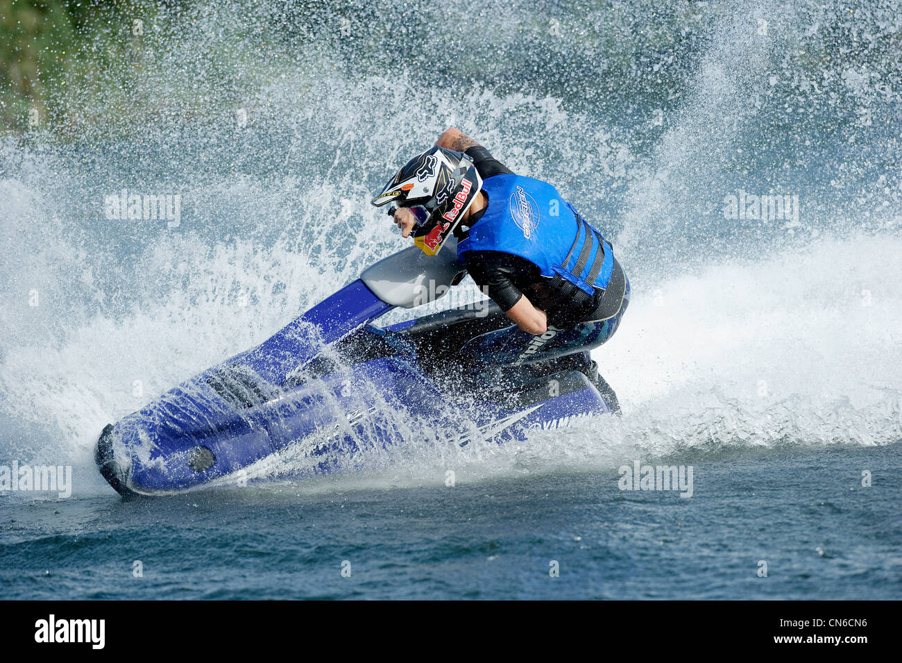 jet skiing across lake with water spray behind Stock Photo - Alamy