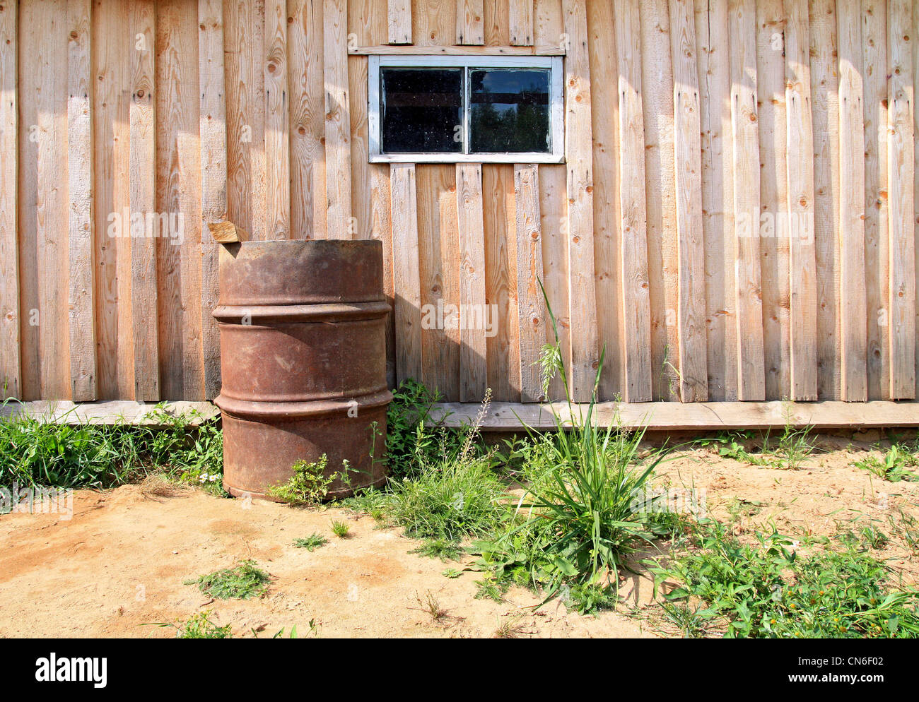 rusty barrel near wooden shed Stock Photo - Alamy