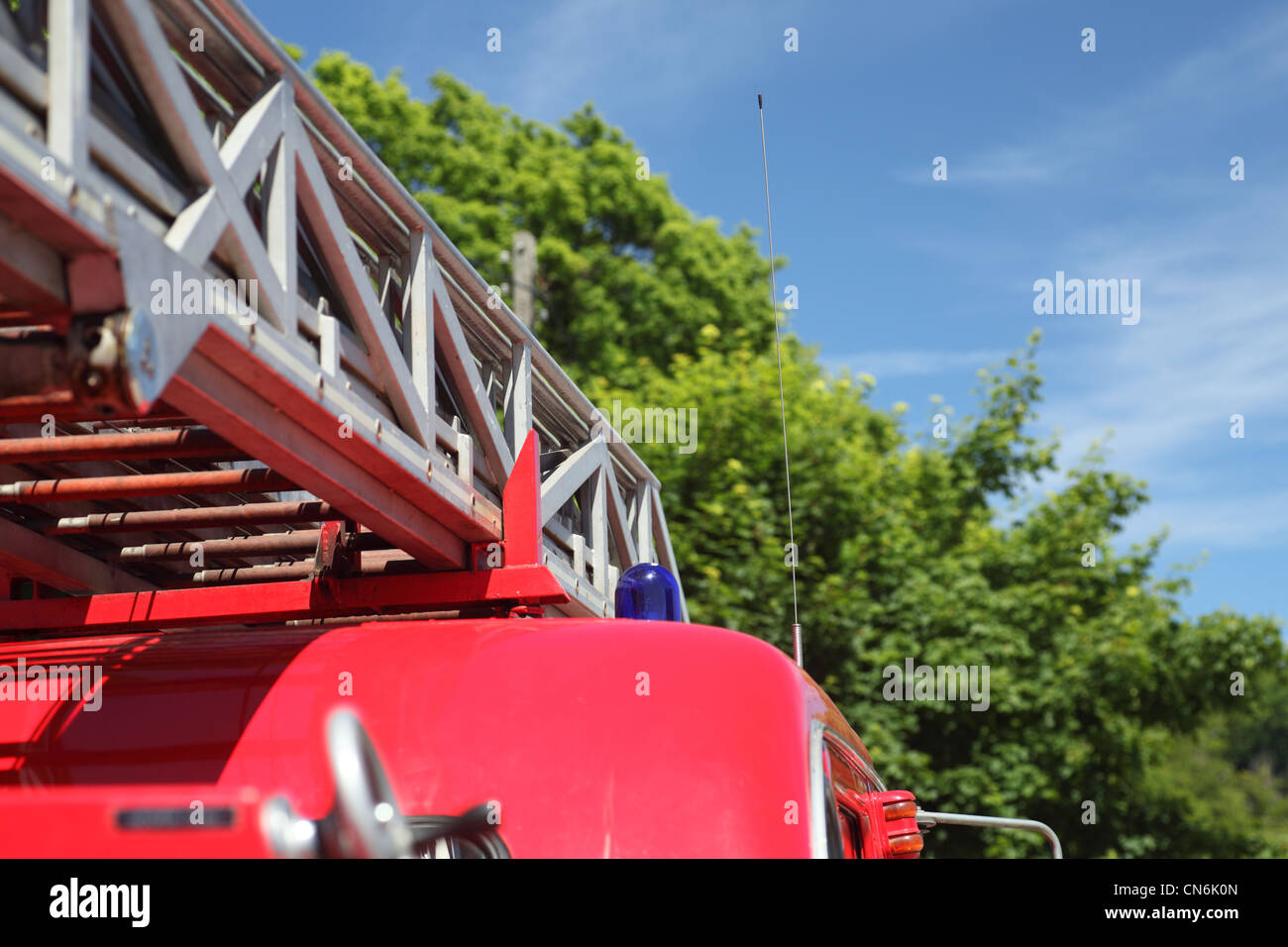 Ladder of a fire truck on the blue sky, emergency light on firetruck ...