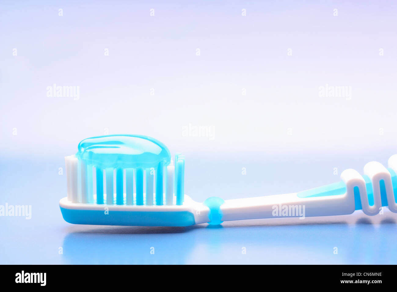 Blue toothbrush with blue toothpaste on a blue background Stock Photo ...