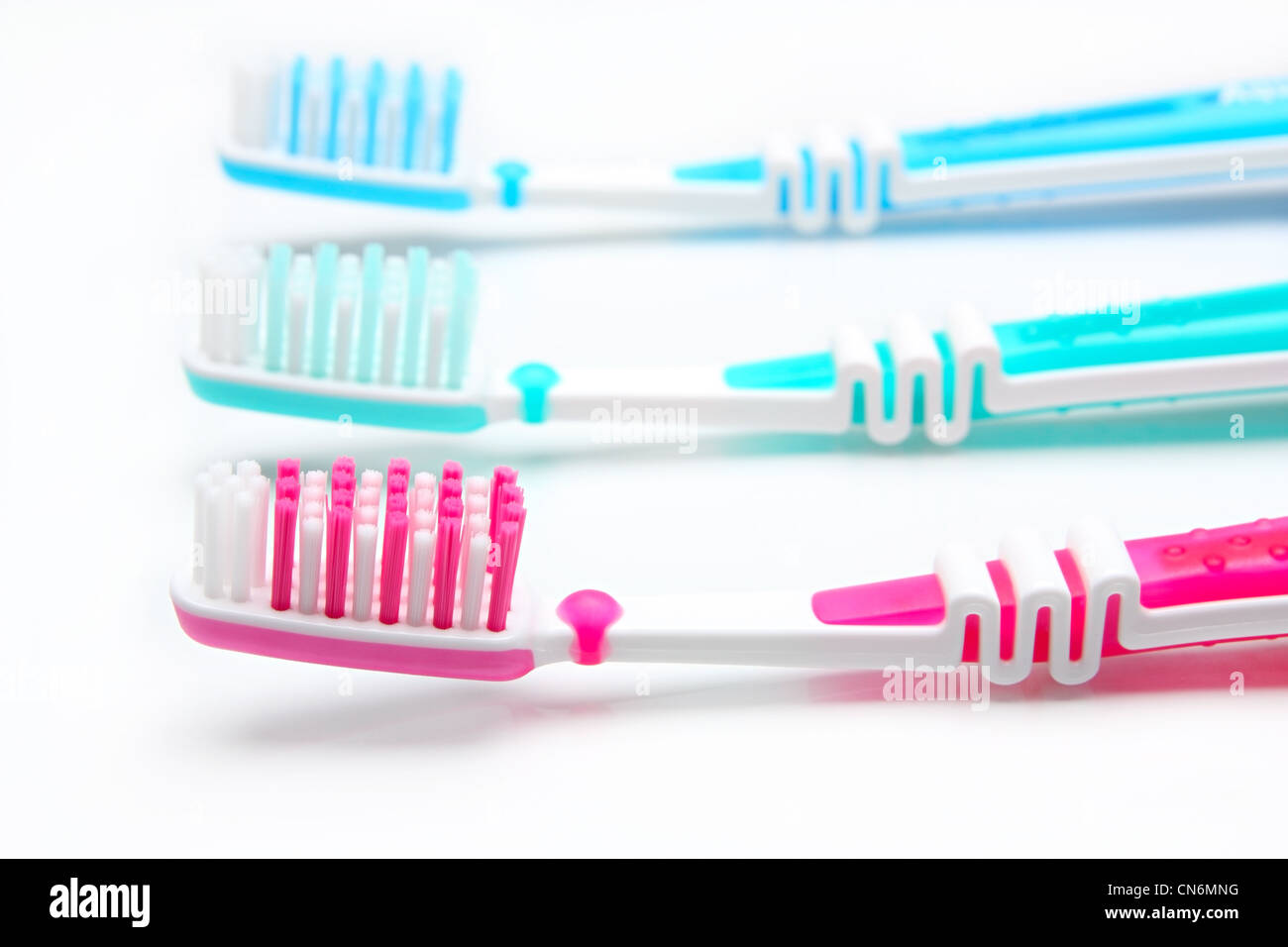 Three toothbrushes red, green and blue on a white background Stock ...