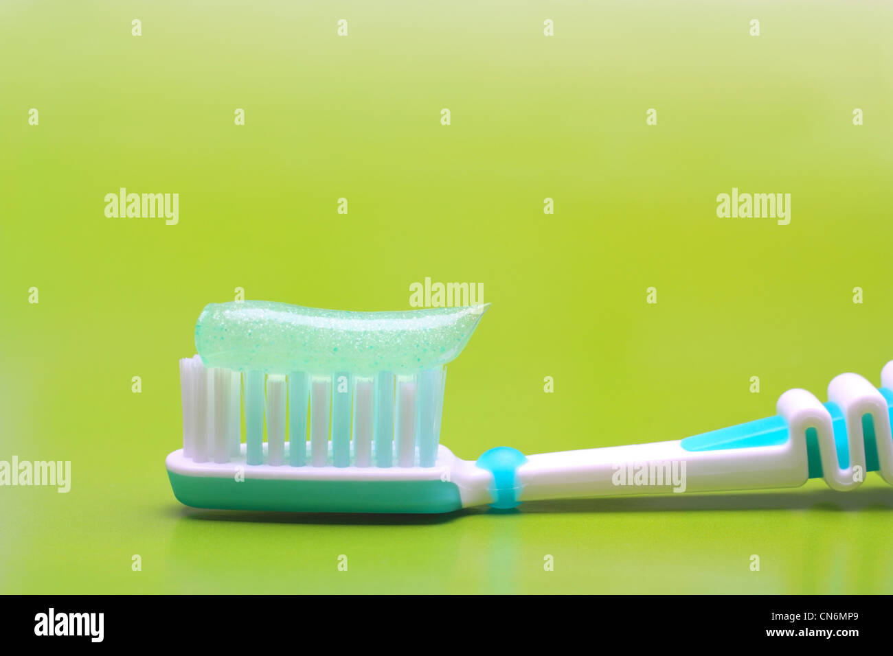 Green toothbrush with green toothpaste on a green background Stock ...