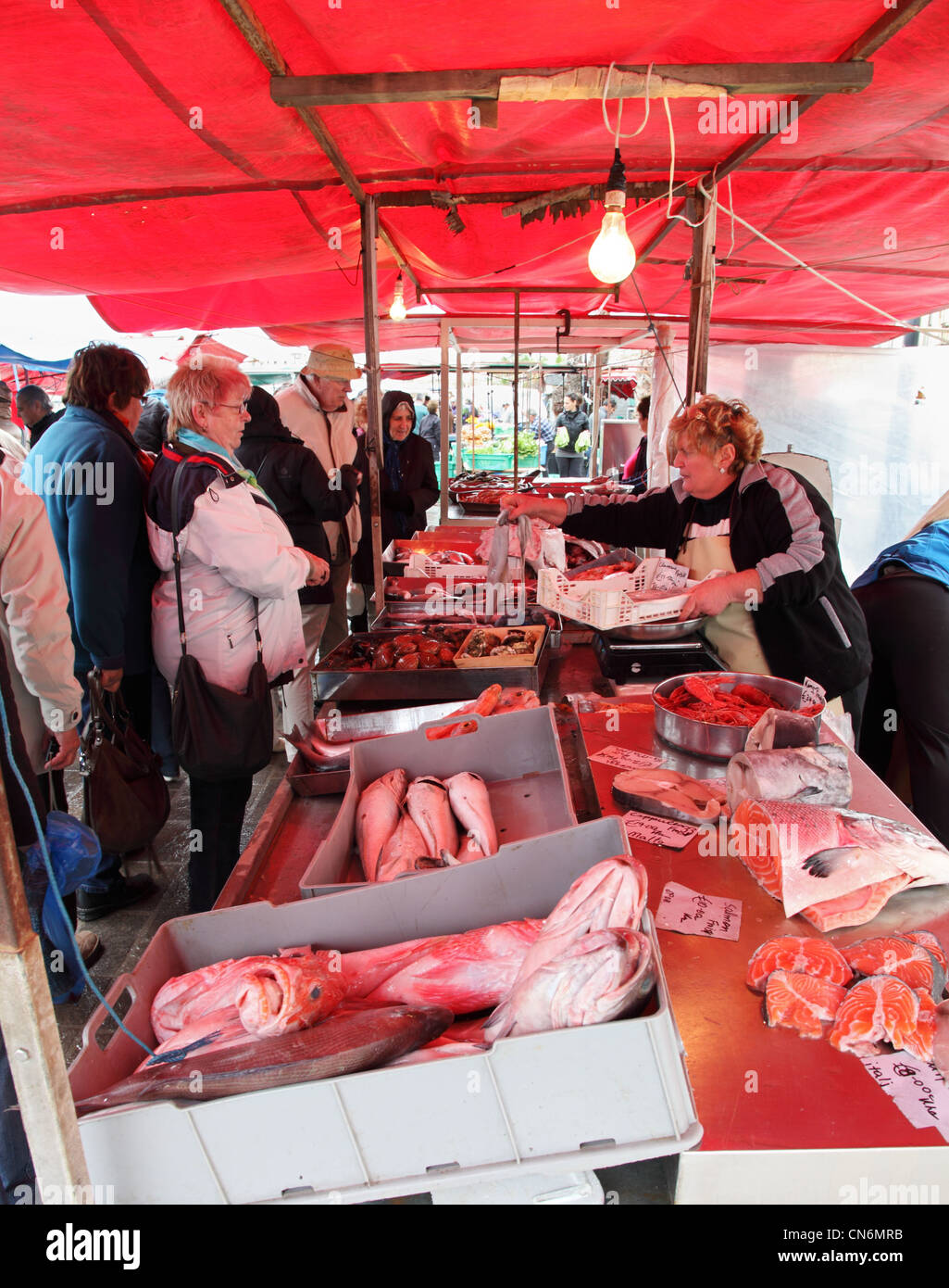Selling fish from a market stall in the fishing village of Marsaxlokk ...