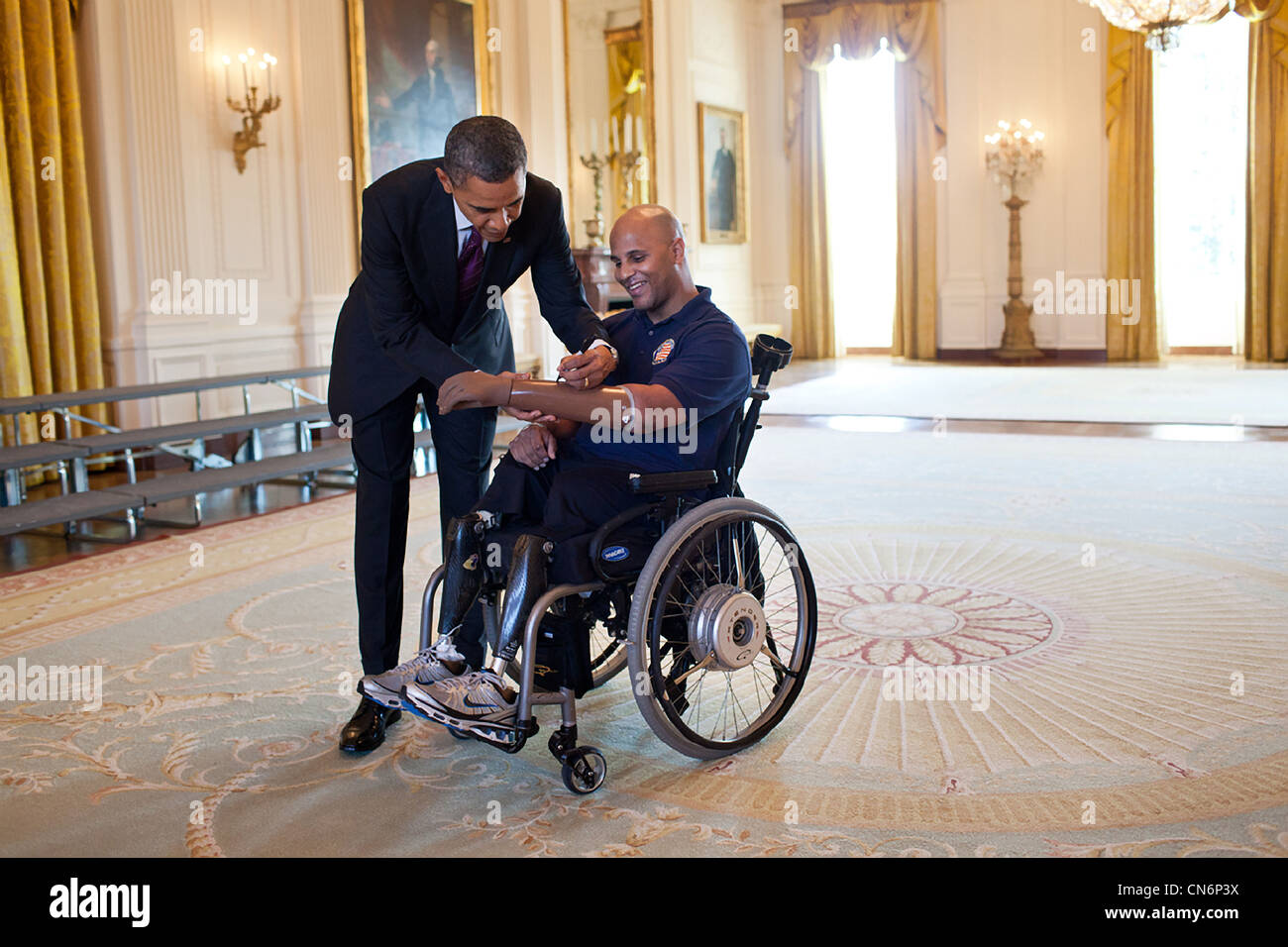 President Barack Obama signs the prosthetic arm of Sgt. Carlos Evans ...