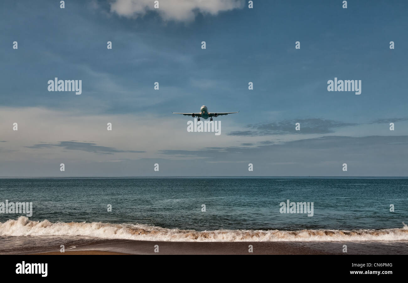 Passenger plane landing approach over a tropical beach Stock Photo - Alamy