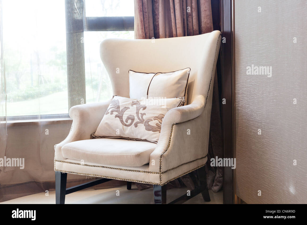 Armchair close to the window at a new interiors Stock Photo - Alamy