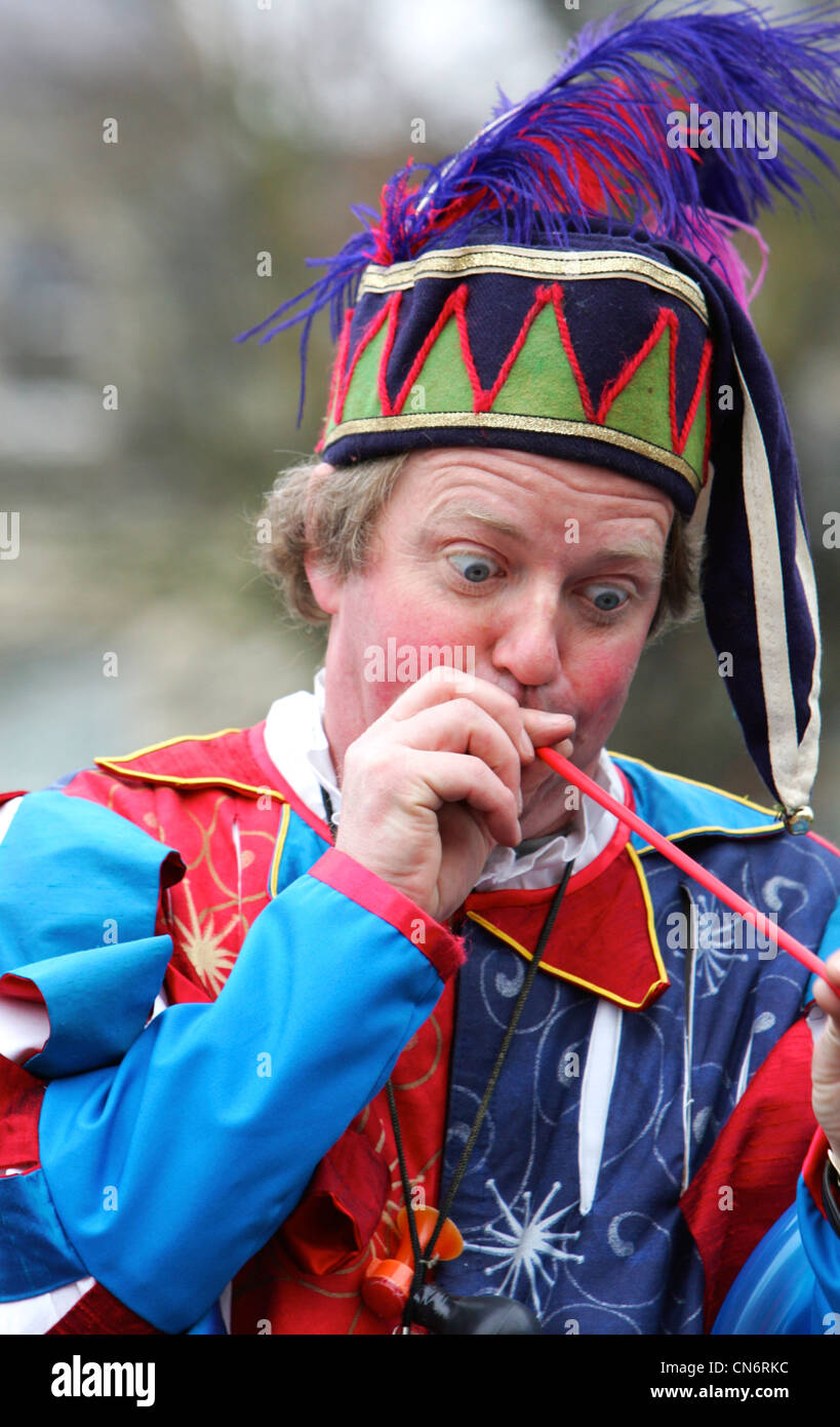 Street entertainer dressed as a jester blowing up balloons Stock Photo ...