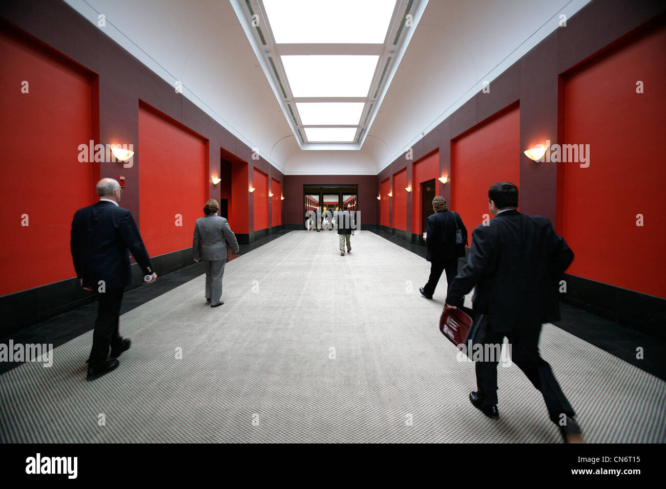 People walking in a long red hallway in the Hynes Convention Center in ...