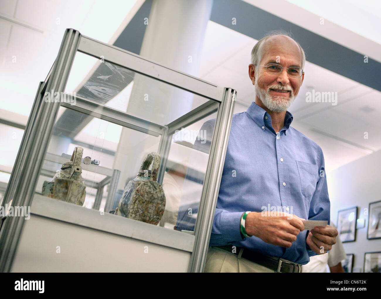 Computer scientist Martin Newell poses by teapots in an exhibit ...