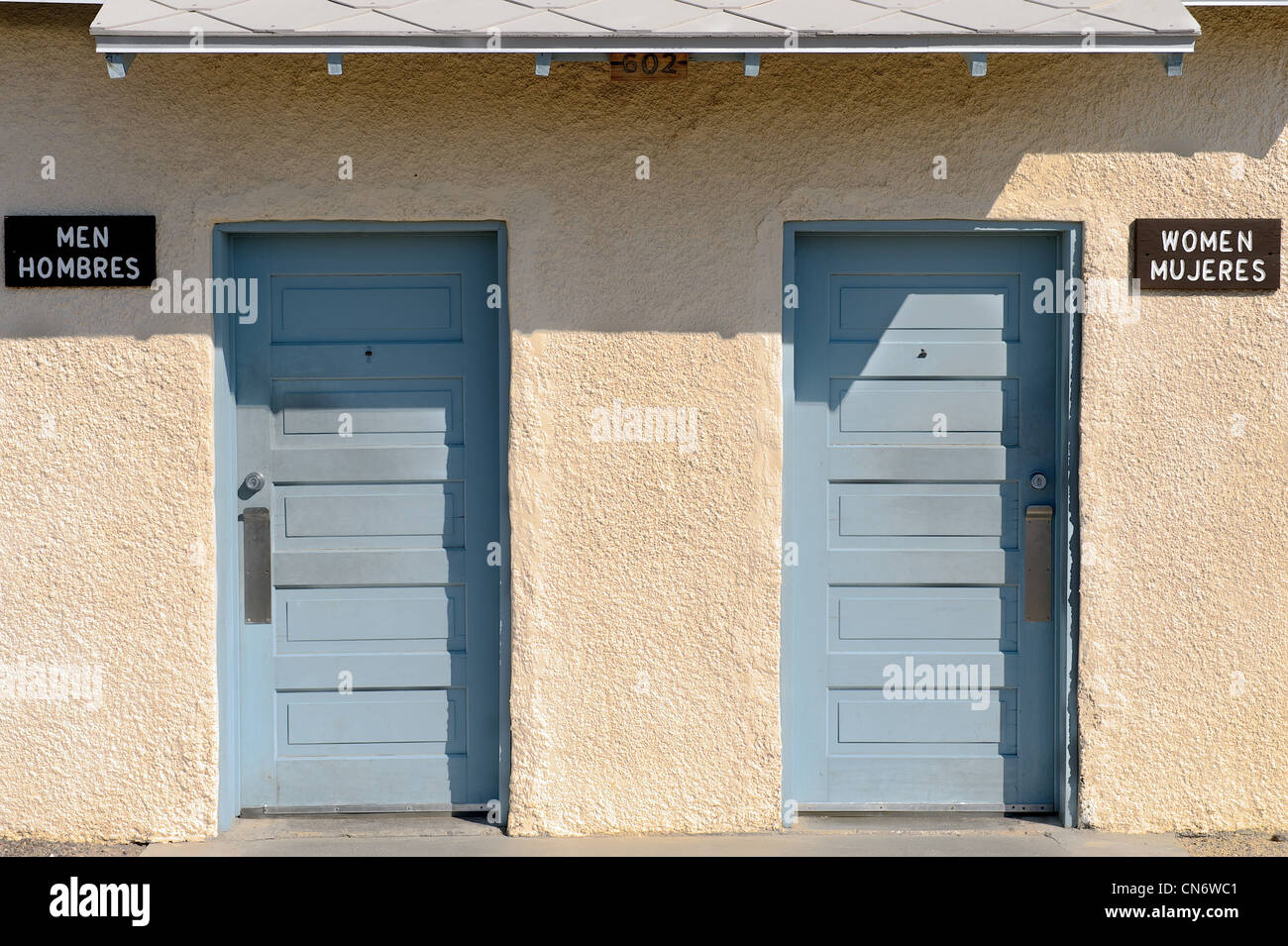 Male and female with bilingual signs in English and Spanish ...
