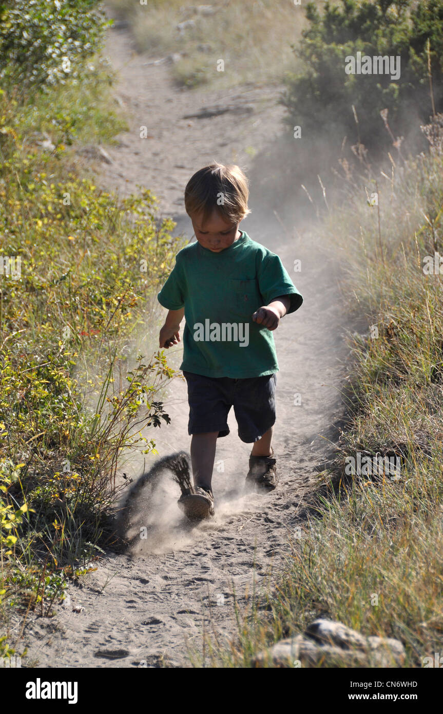 Young boy walking a trail Young boy walking up granite slope in Oregon ...