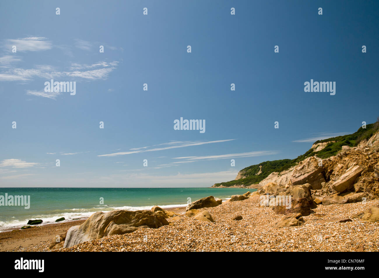 Rocks in the sea under sandstone cliffs at Fairlight Cove, part of ...