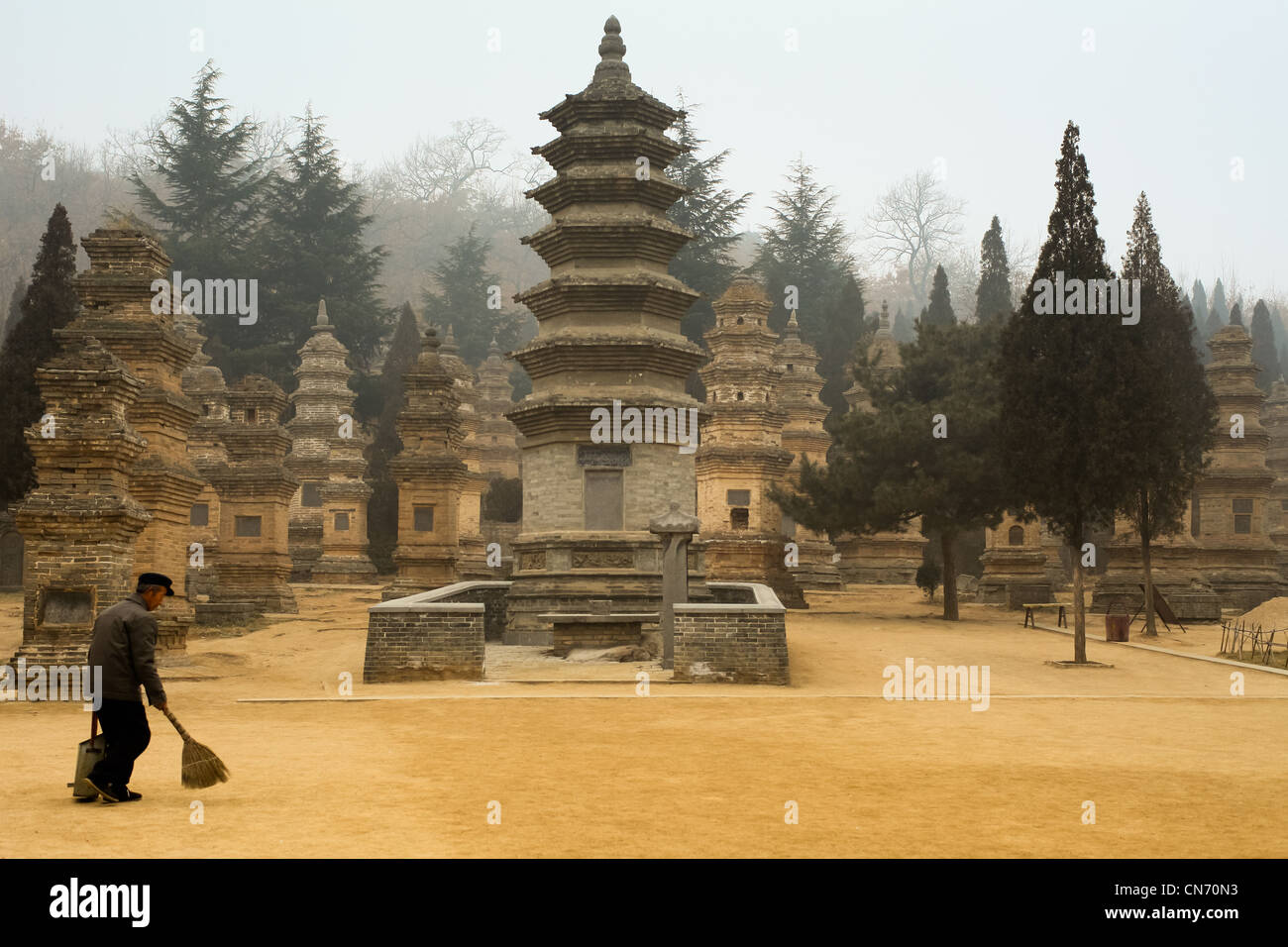 A chinese man sweeping the grounds of the pagoda forest in the Shaolin ...