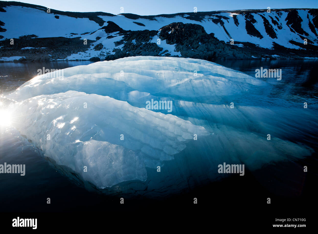 Norway, Svalbard, Nordaustlandet, Midnight sun lights iceberg along ...
