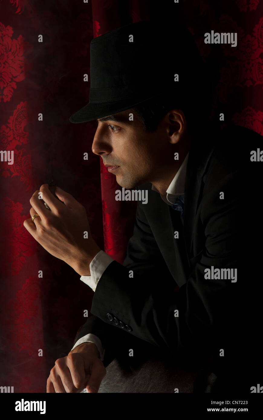 Elegant man with hat smoking in the night Stock Photo - Alamy