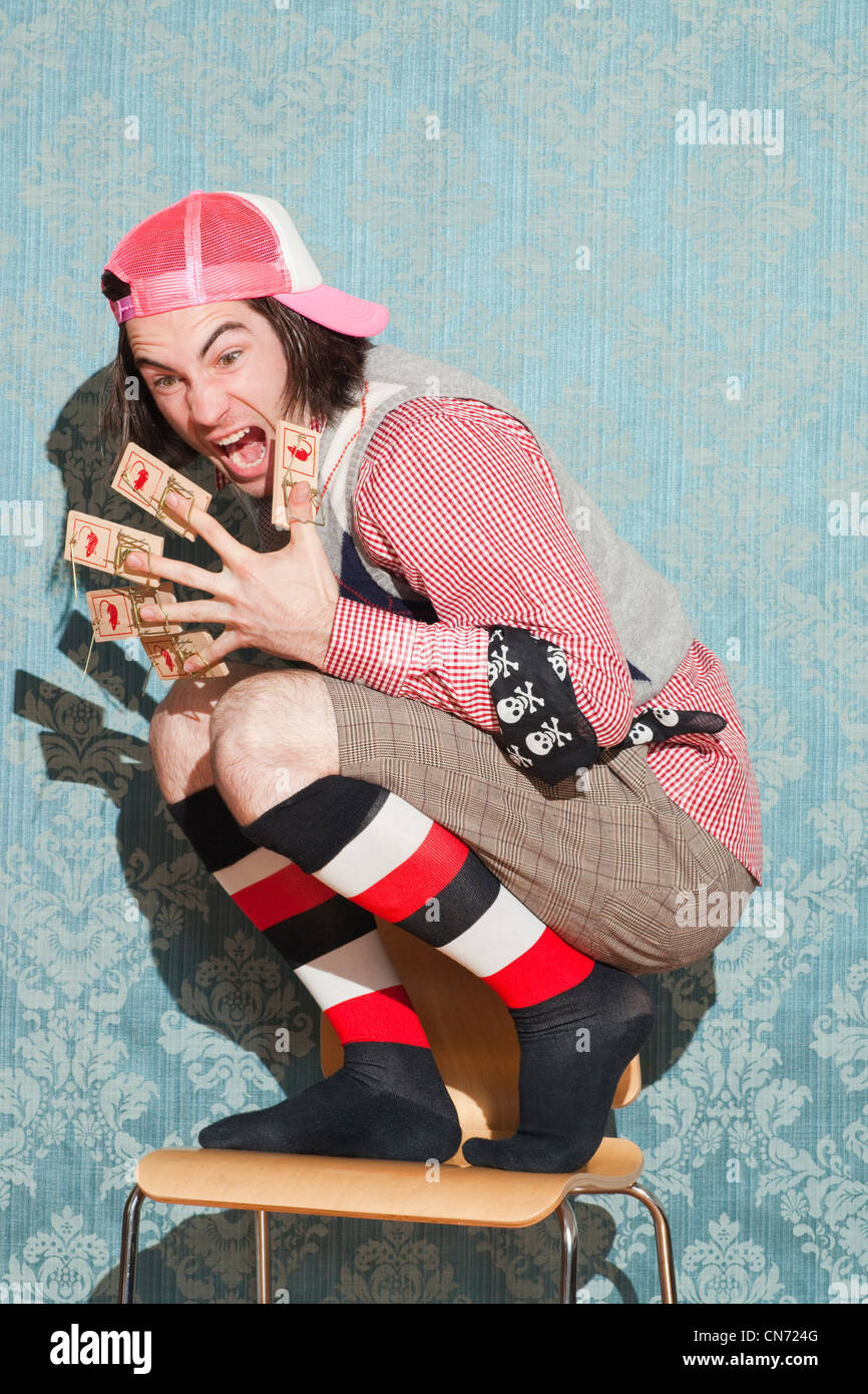 Portrait of caucasian young man screaming in pain on chair with fingers ...