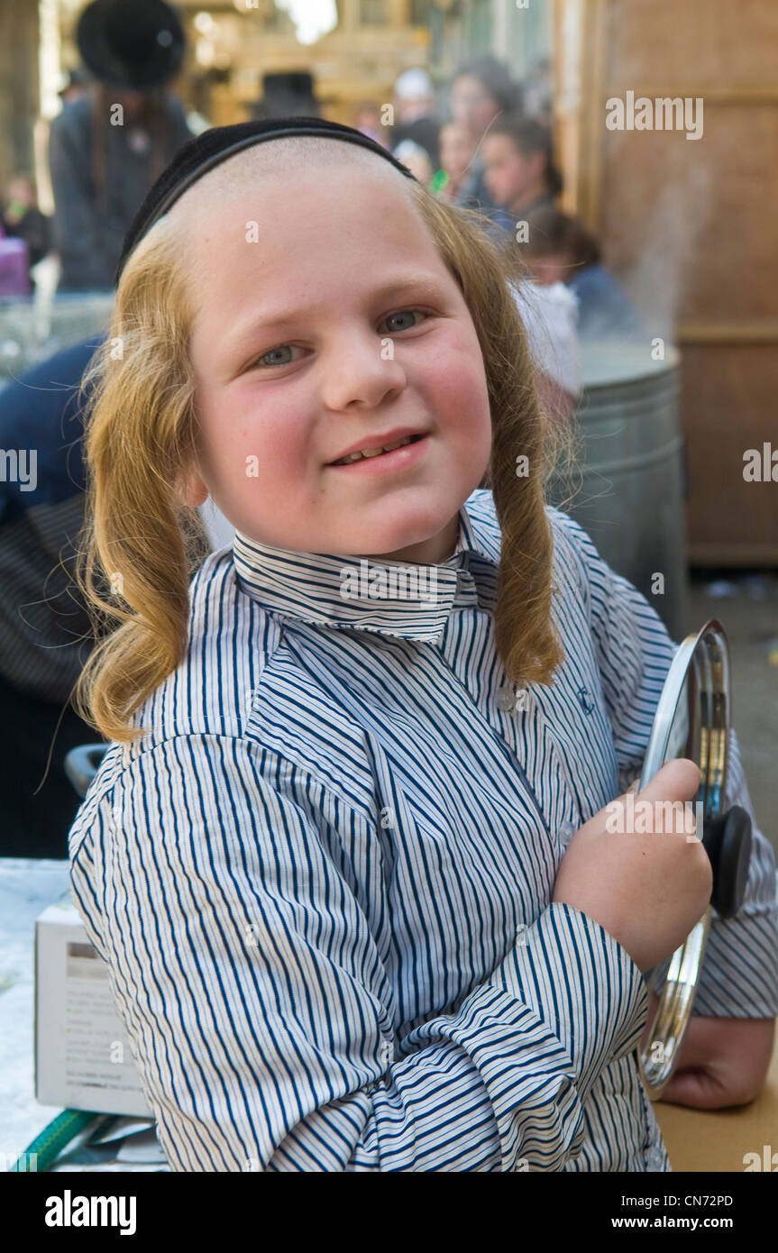 An Ultra Orthodox child is helping is dad preparing to the Jewish ...