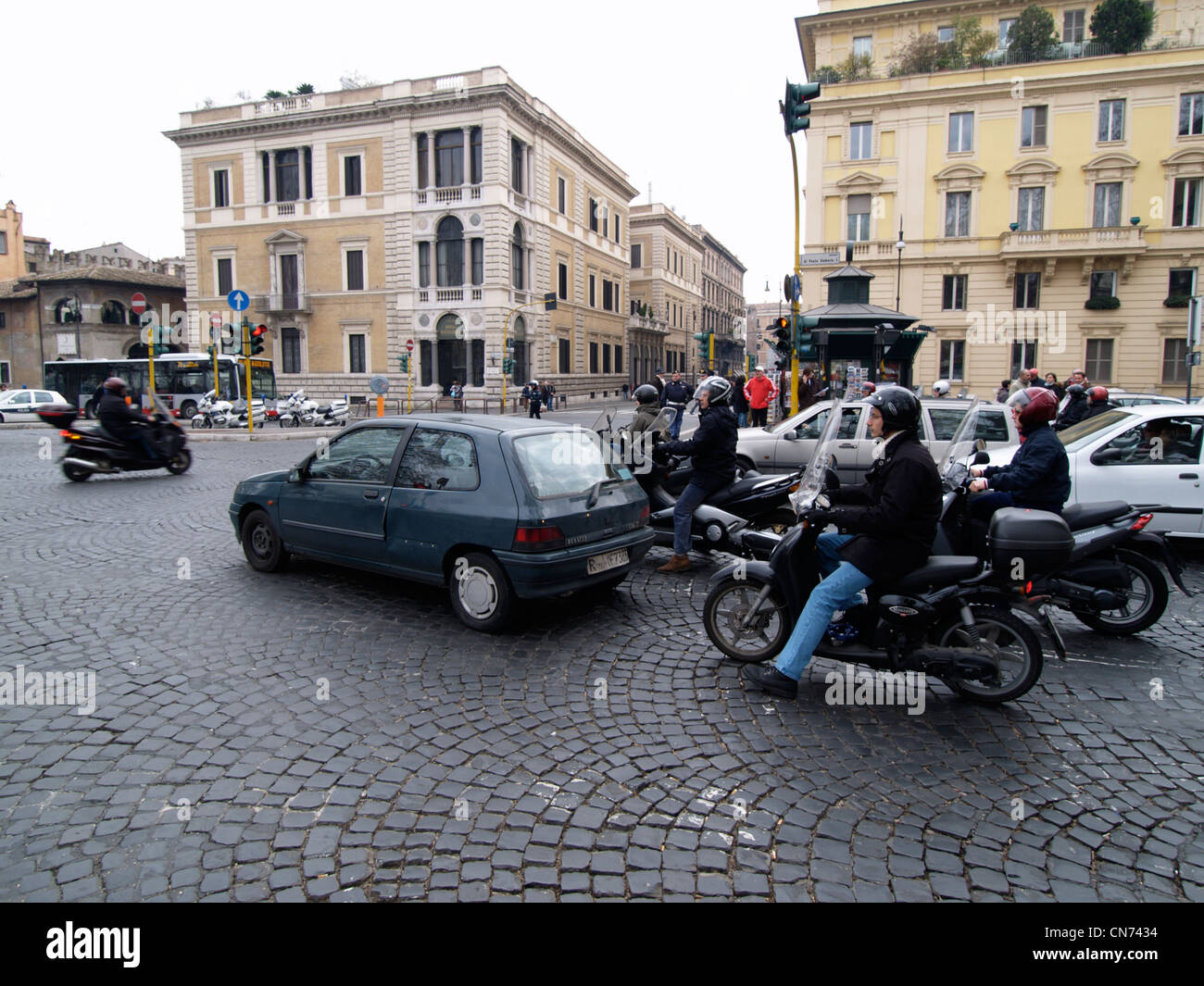 Many cars and scooters waiting for a traffic light in Rome Italy ...