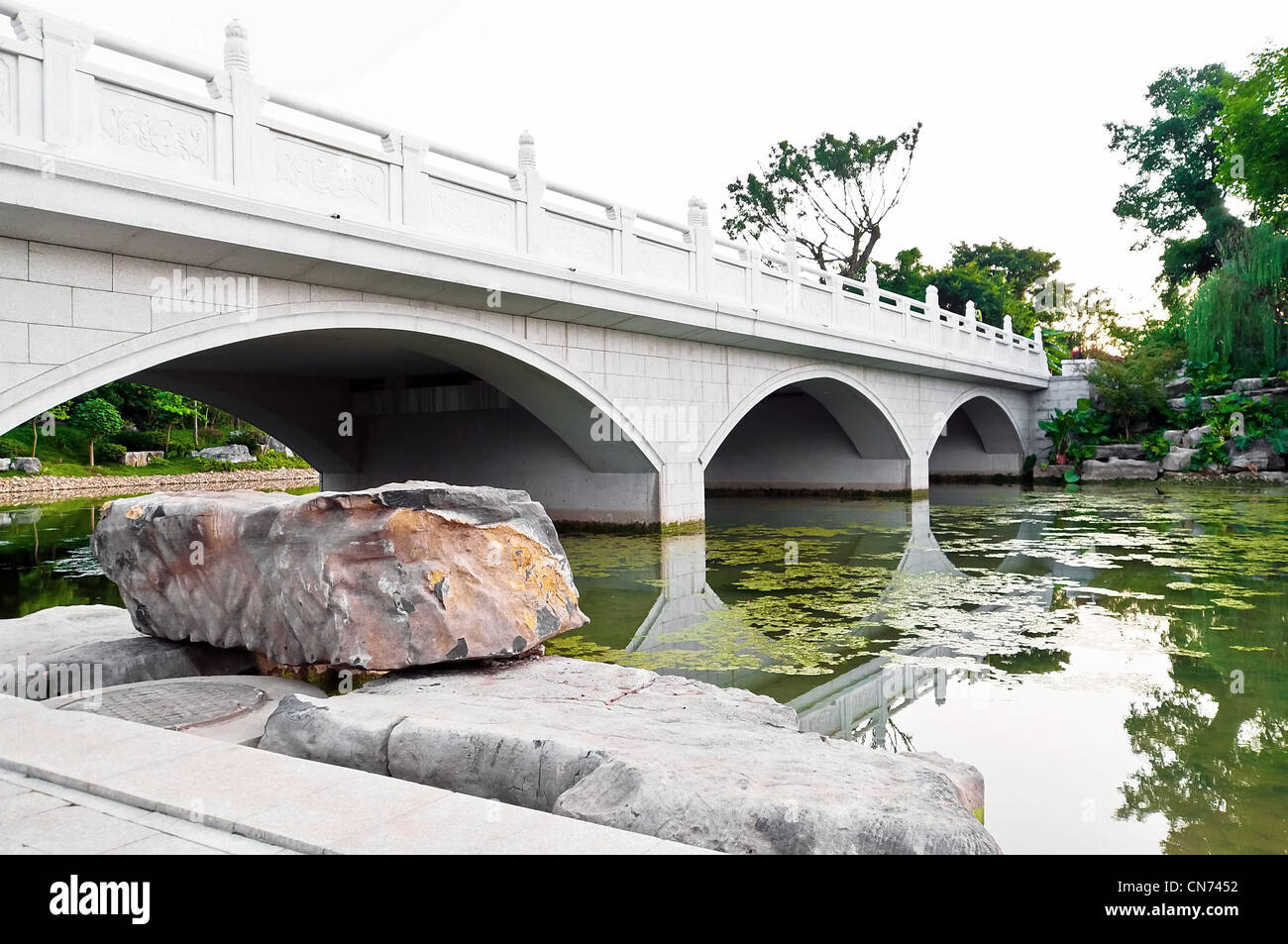 White chinese bridge over a river in a city park Stock Photo - Alamy