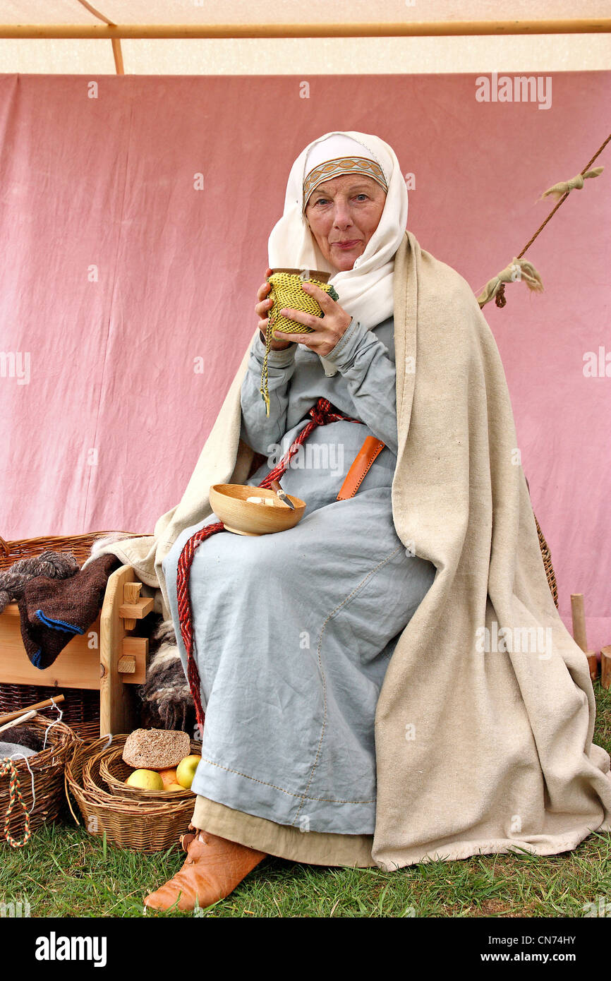 An elderly Saxon woman wearing period traditional costume sitting down ...