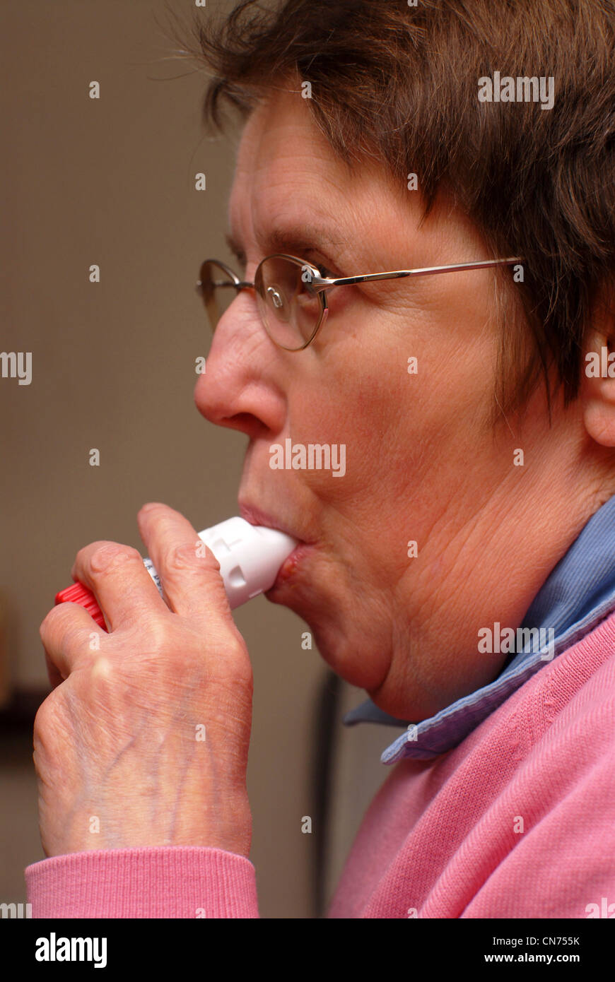 Elderly woman with asthma using inhaler to alleviate symptoms, Reading ...
