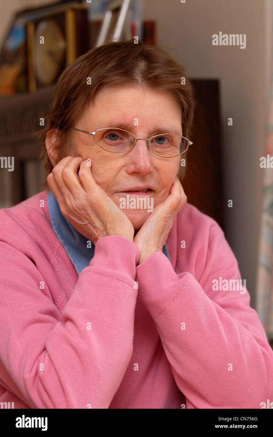 Elderly woman sitting down resting her hand on her face, Reading, UK ...