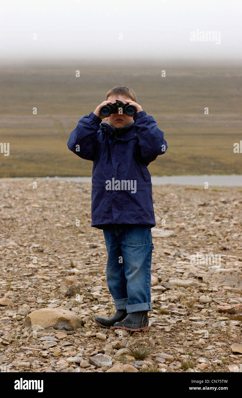 Boy using binoculars, Nunavut, Base of Mount Pelly, Victoria Island ...