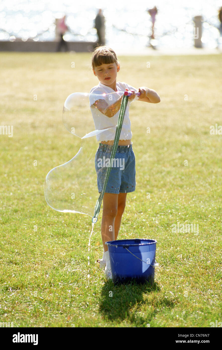 Girl Making Bubbles in Park Stock Photo - Alamy