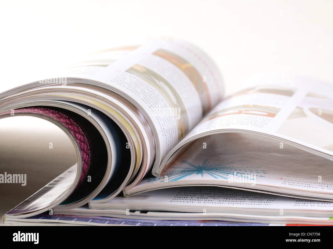 pile open magazines on a white background Stock Photo - Alamy