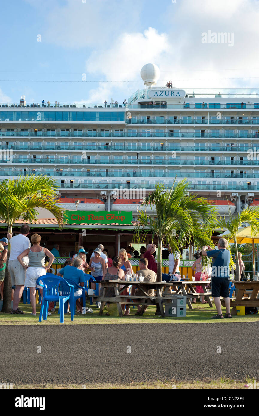 Tourists outside The Rum Shop with P&O's cruise ship Azura behind ...