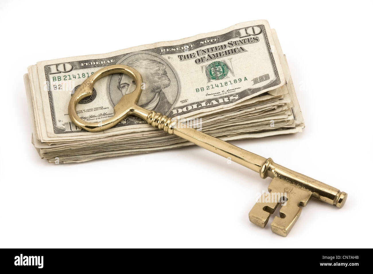 Money and brass key isolated on white background Stock Photo - Alamy
