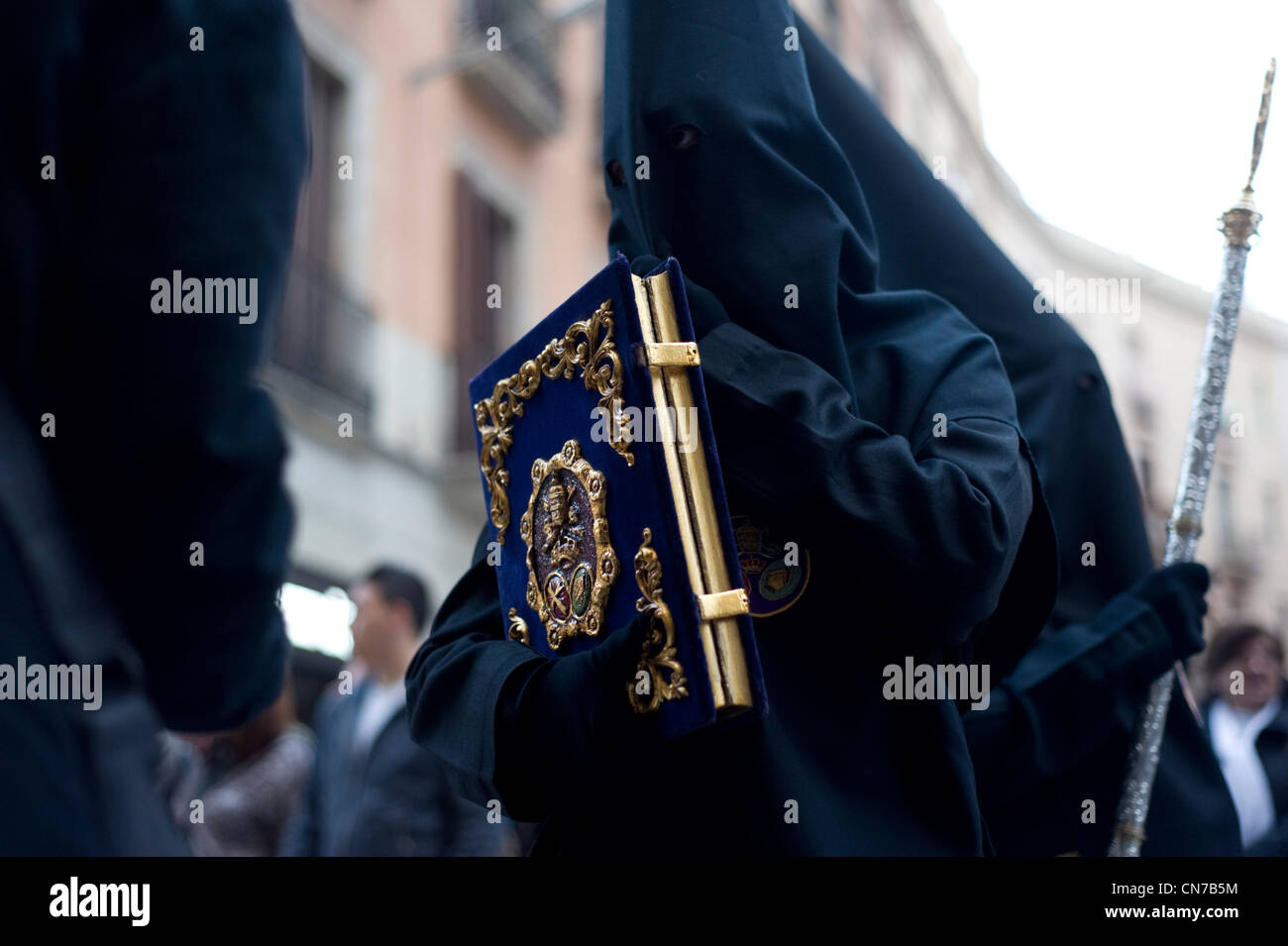 Penitent carrying a sacred book in a procession of Holy Week in ...