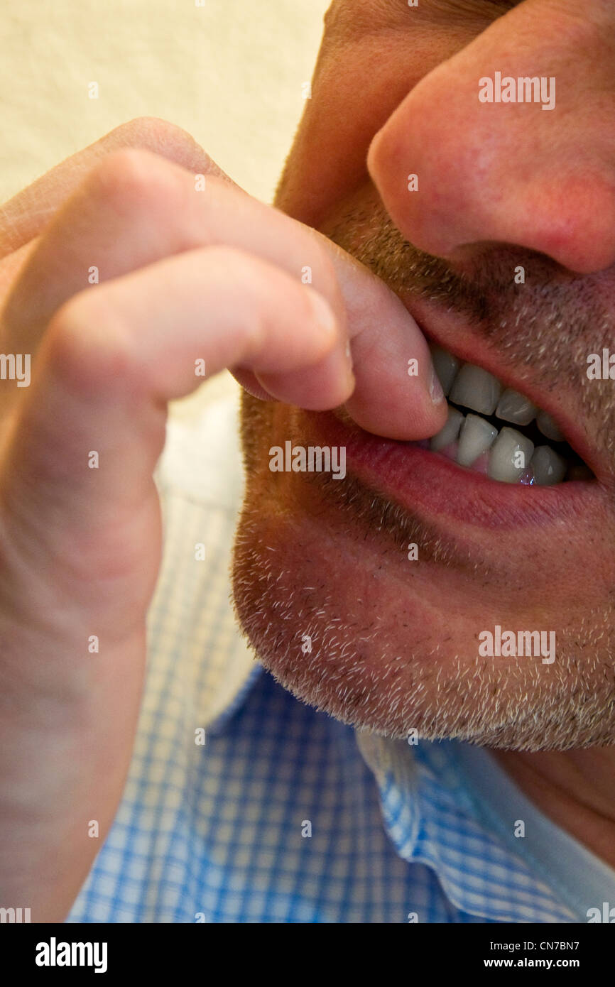 Man biting his nails Stock Photo - Alamy