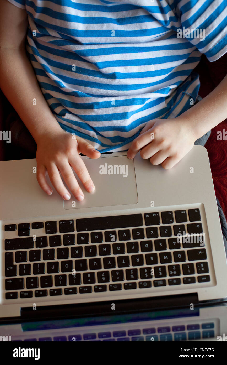 A young boy using an Apple Mac laptop computer Stock Photo - Alamy