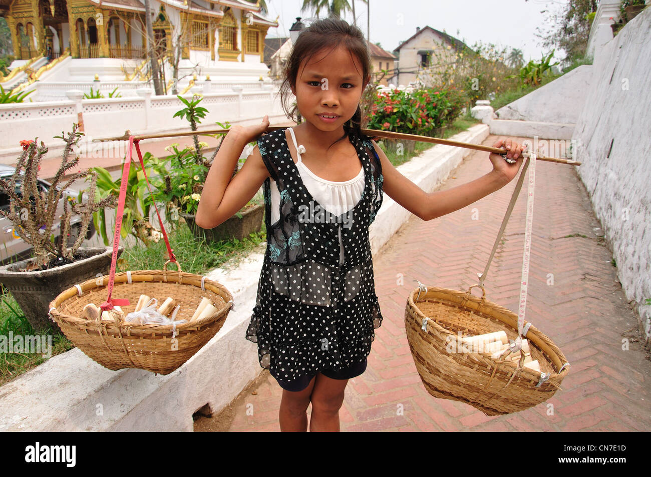 Young girl with bamboo carrying pole by steps to Mount Phou Si, Luang ...