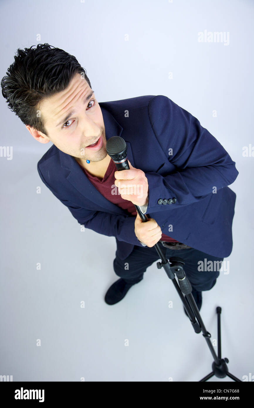 Singer with microphone standing and looking into camera Stock Photo - Alamy