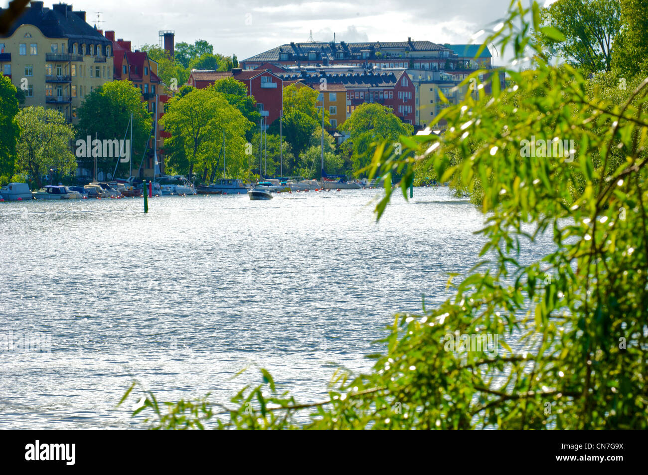 City buildings and boats by the shore of lake Mälaren in Stockholm ...
