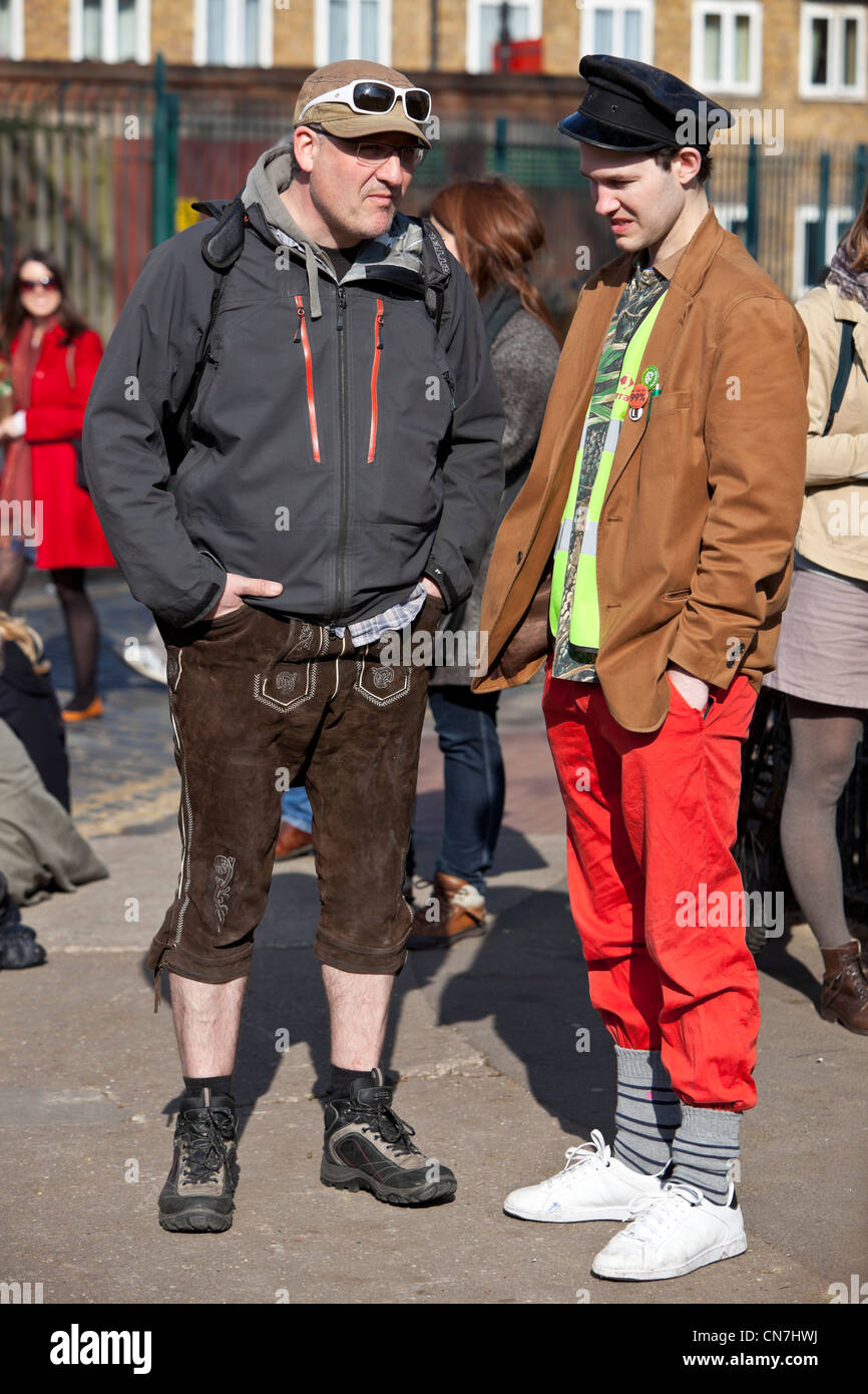 Full length portrait of two trendy men talking and standing on the ...