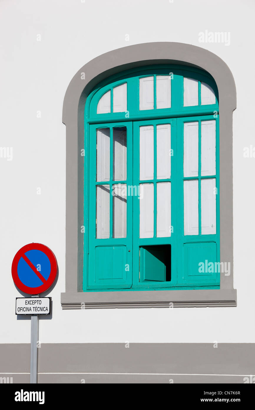 White building with turquoise window frame and bright sign in lanzerote ...