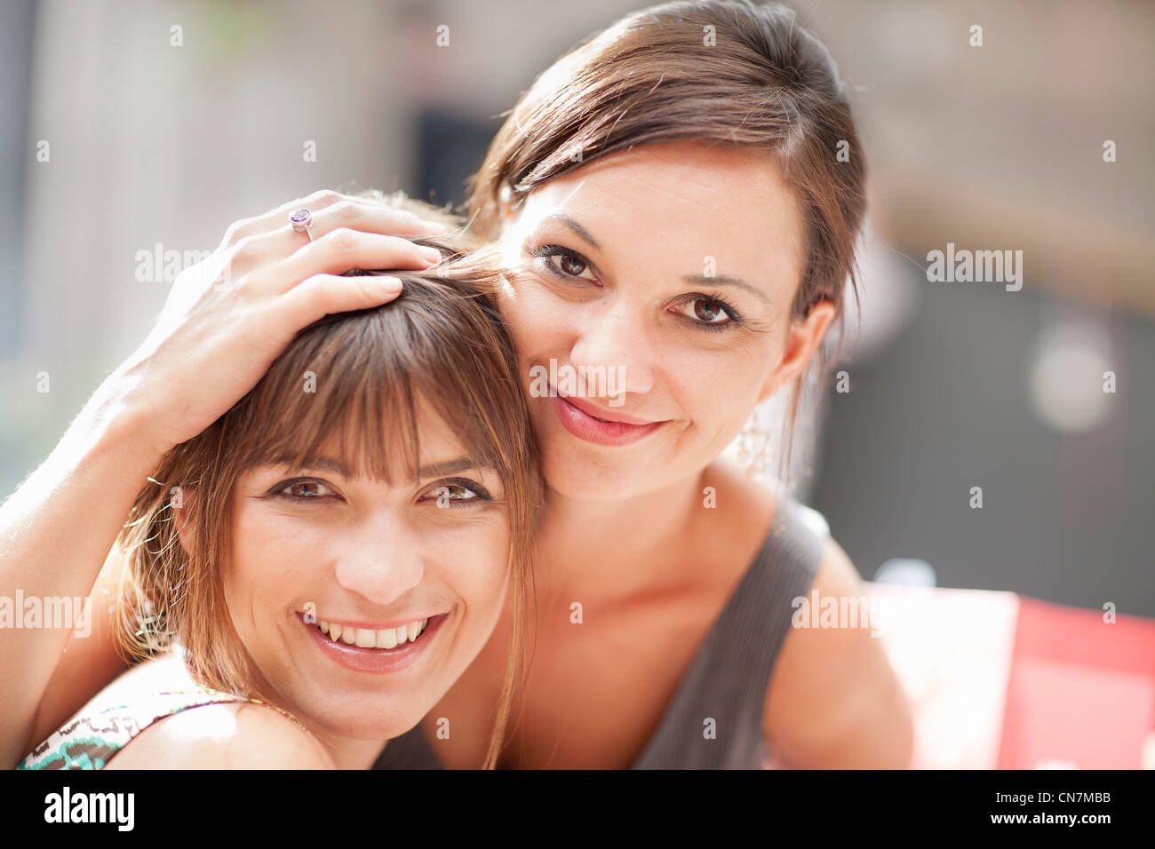 Smiling women hugging indoors Stock Photo - Alamy