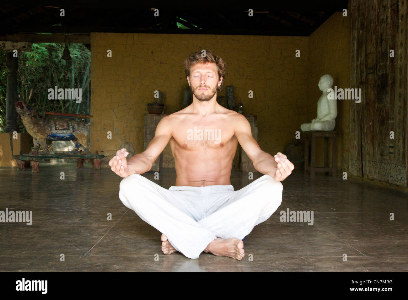 Man meditating in yoga studio Stock Photo - Alamy