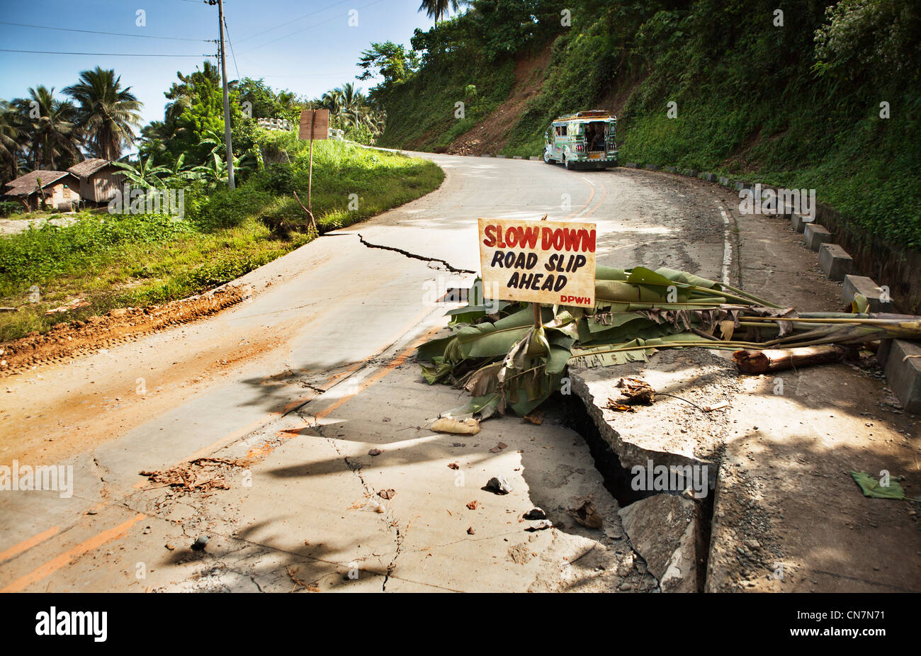 Cracks in road with warning sign Stock Photo - Alamy